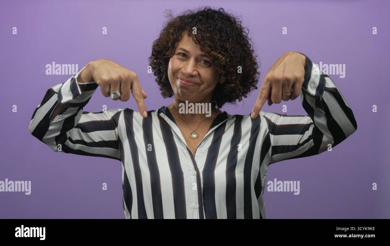 Woman points both index fingers toward necklace on striped shirt in ...