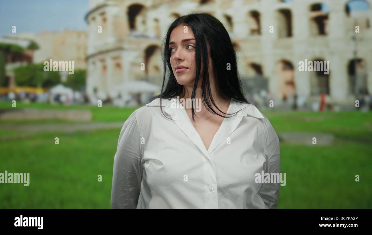 Young woman with long black hair stands confidently in front of the ...