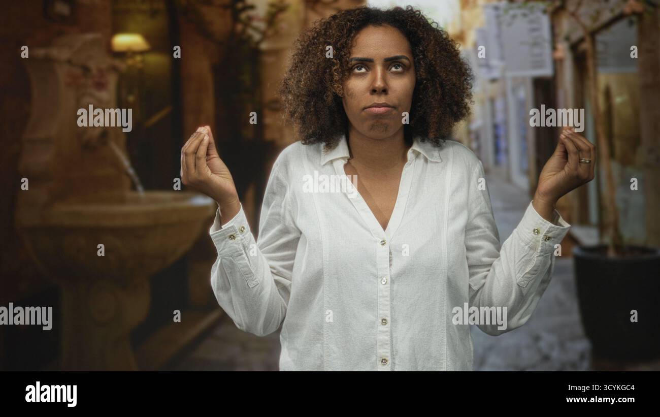 Young african american woman making pinched fingers gesture in narrow ...