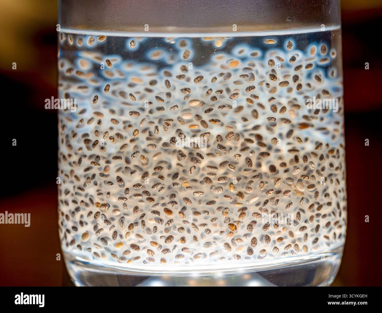 Macro photo of chia seeds floating in a glass of water. A healthy and ...