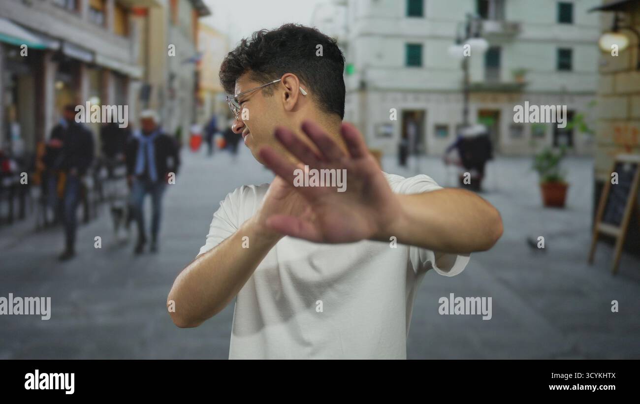 Man pushes forward his hands in a stop gesture and grimaces adjusting ...