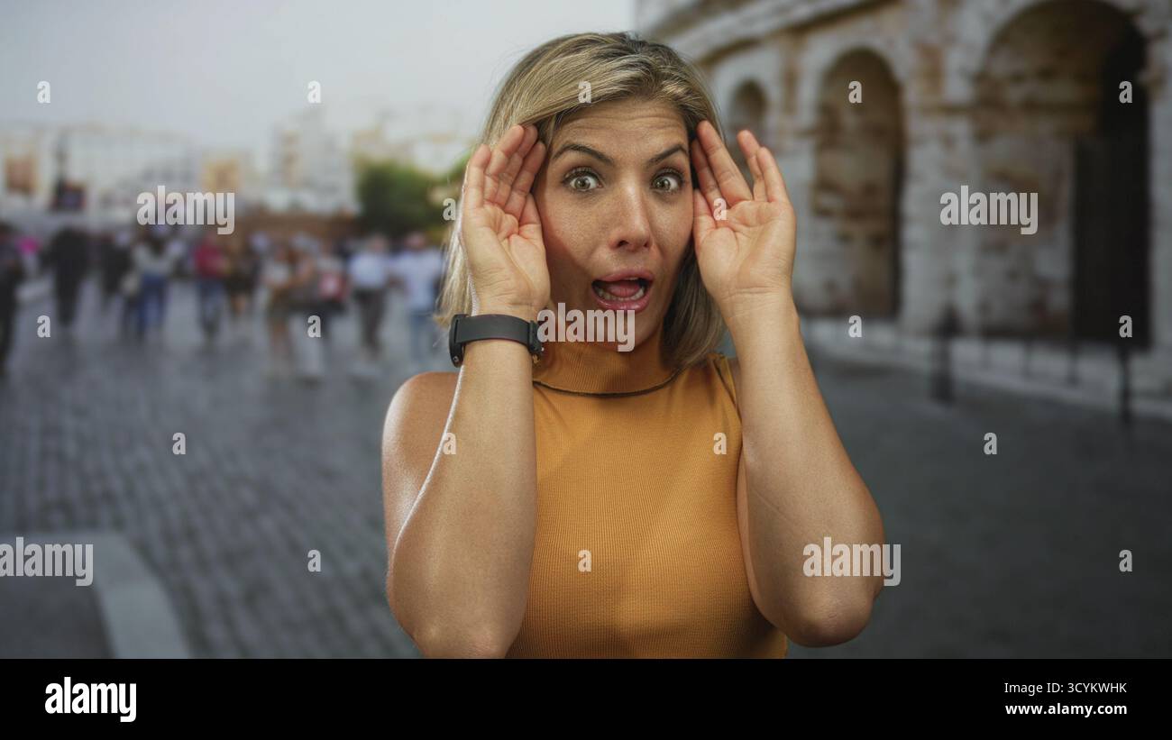 Woman covers face with hands at roman coliseum building, smiling as she ...