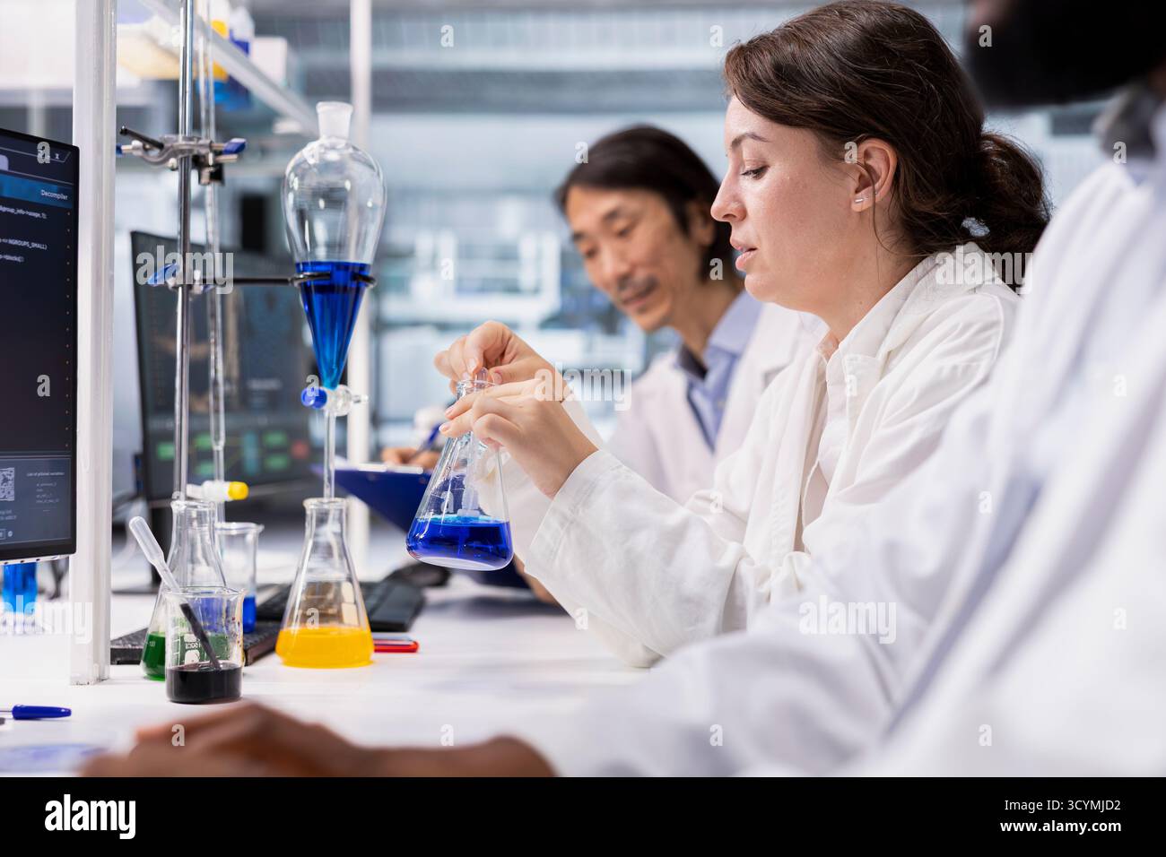 Chemical engineers using scientific gear in research facility used for complex experiments ...