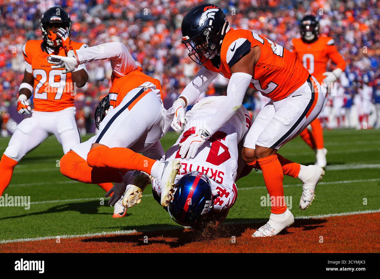 New York Giants running back Cam Skattebo, bottom, scores past Denver ...