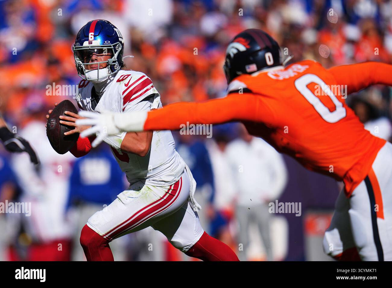 New York Giants quarterback Jaxson Dart (6) rolls out to pass as Denver ...