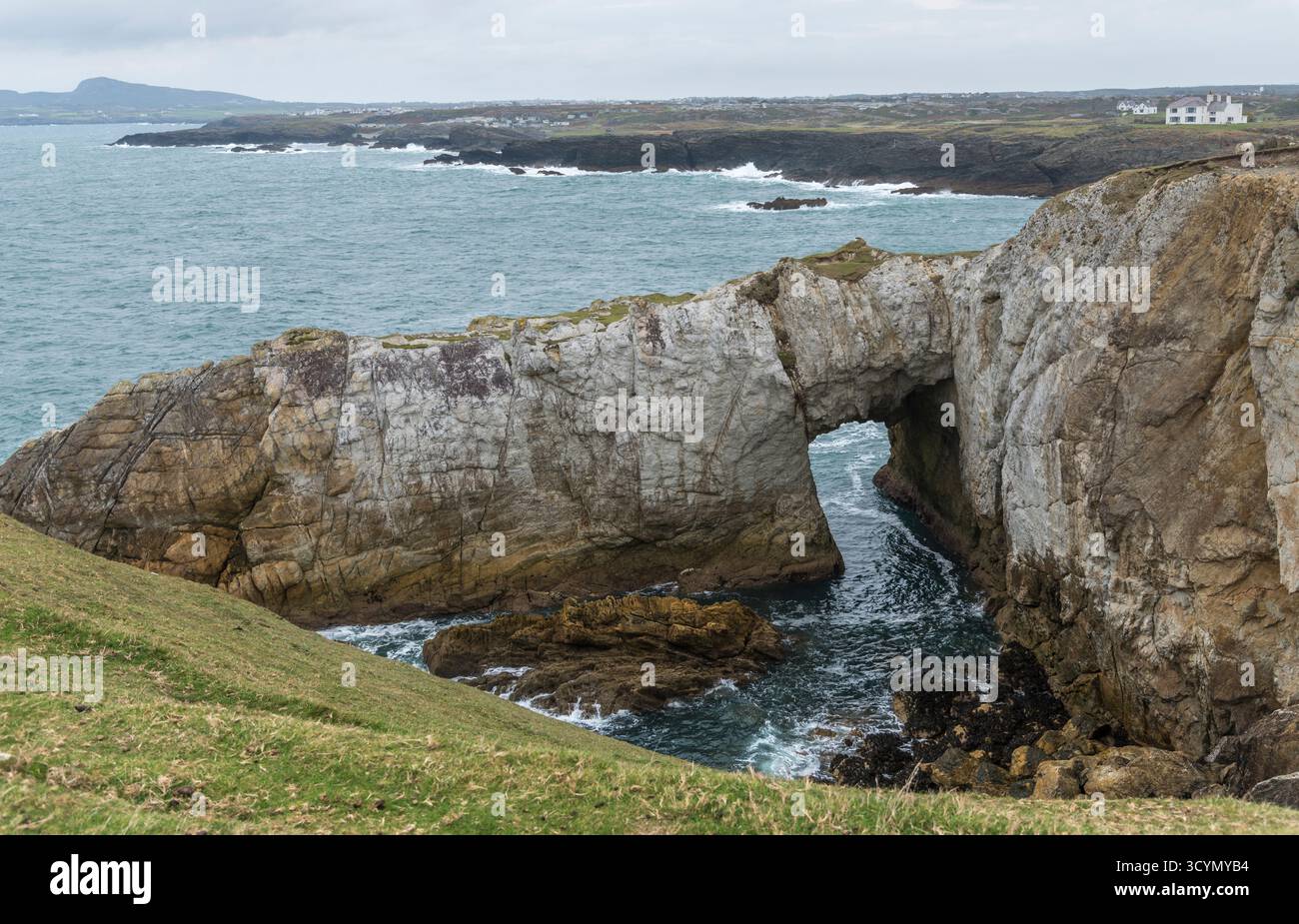 The White Arch (Bwa Gwyn) sea arch from the coastal path near Rhoscolyn ...