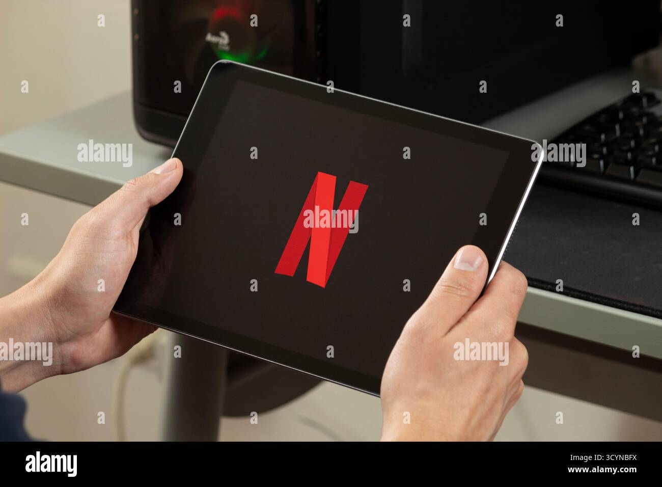 Close up to a male hand holding an iPad with the red N symbol of ...