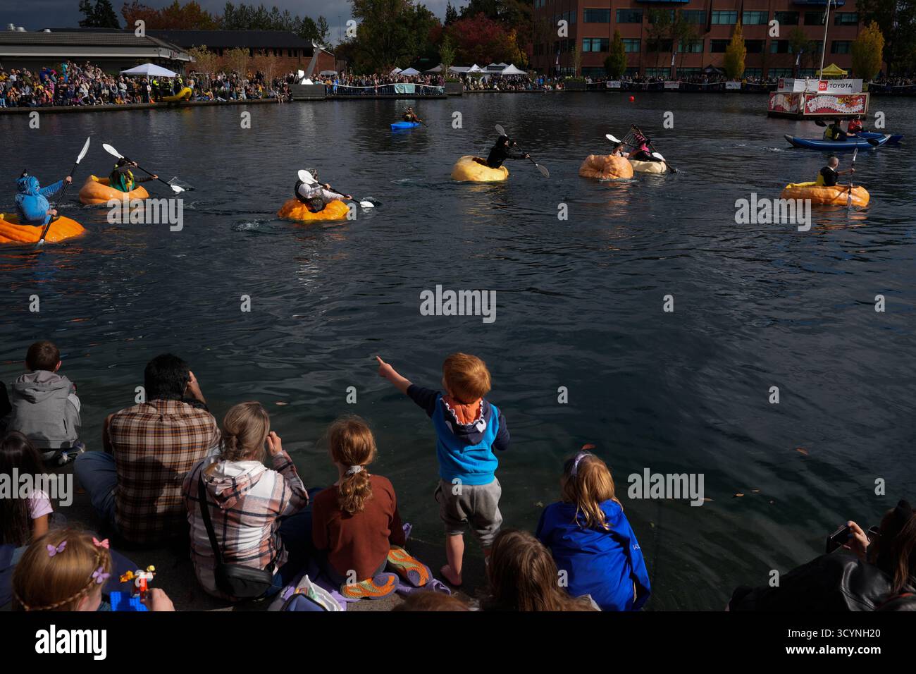A child points to people racing giant pumpkins during the West Coast ...