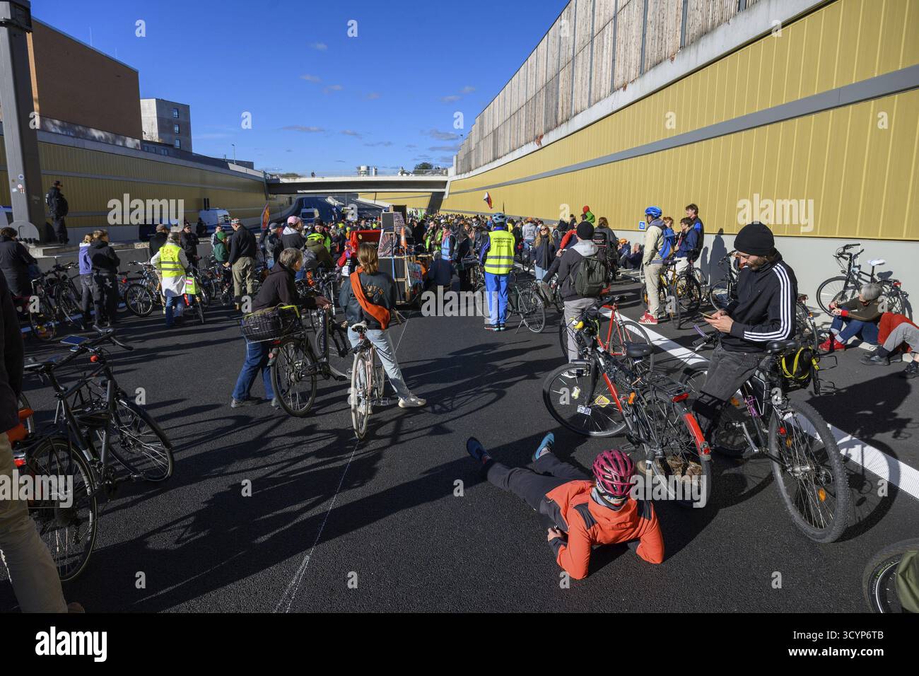 Cyclists wait to continue their journey. Meanwhile, a woman wearing a ...