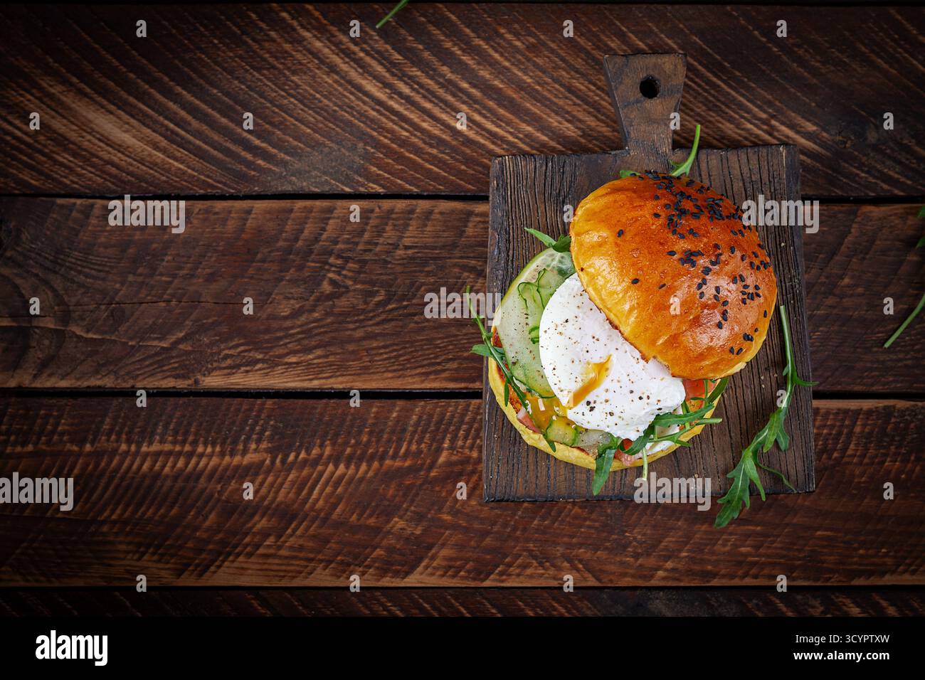 Bun breakfast sandwich with salt salmon, cream cheese and poached egg ...