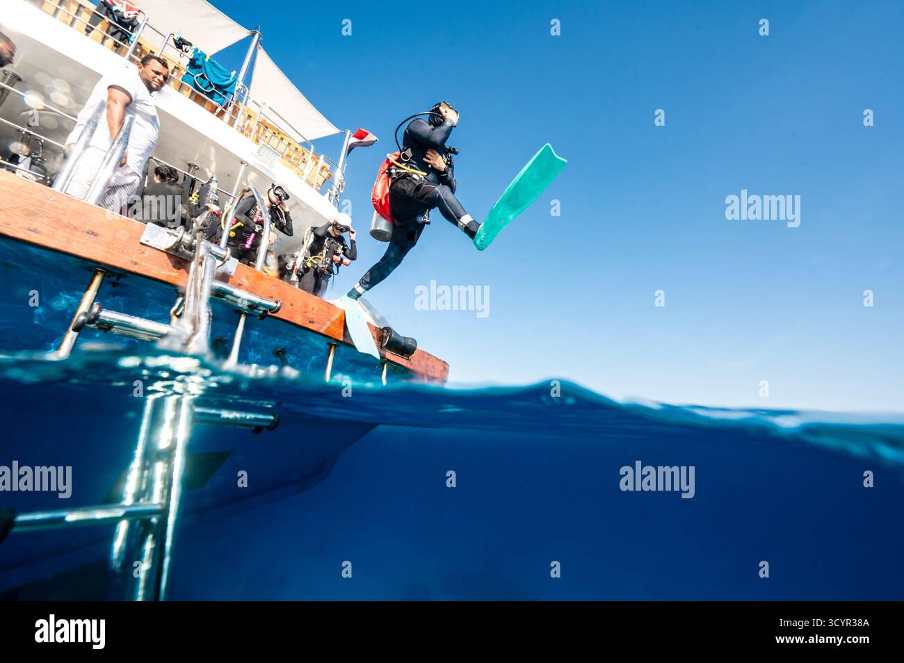diver jumping into the clear water of the Red Sea from a dive boat ...