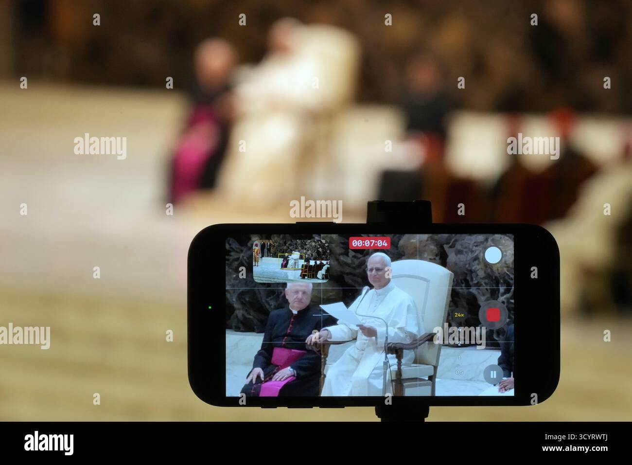 Pope Francis is seen on the screen of a smartphone as he holds an ...