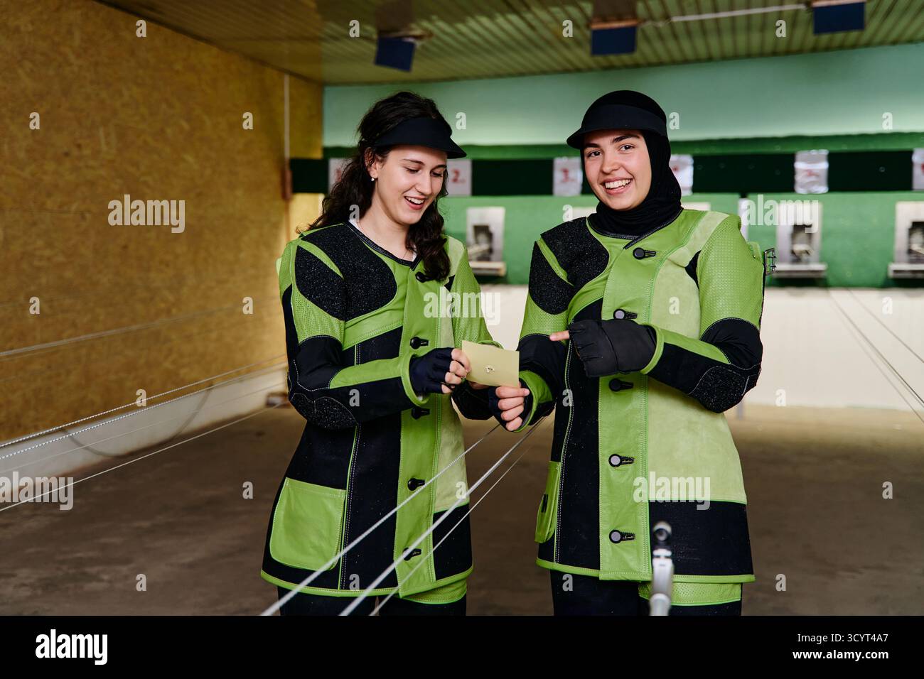 Two women training professional sport shooting at an indoor range ...