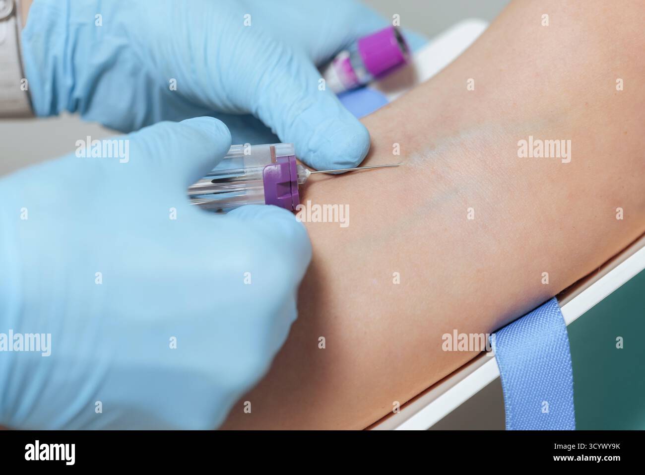 Person performing the blood draw in safety gloves, cleaning the ...
