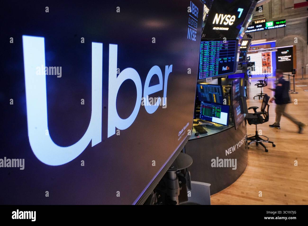 The logo for Uber is displayed above a trading post on the floor of the ...