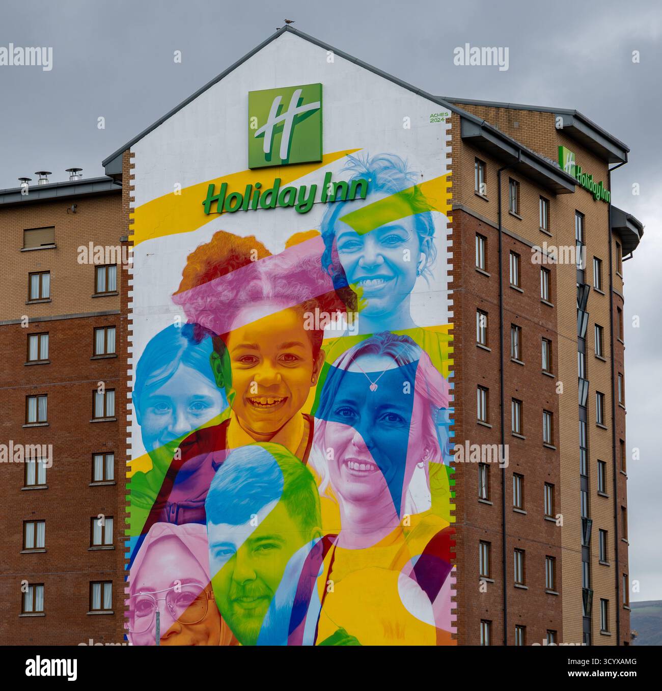 Colorful mural featuring diverse faces on the side of the Holiday Inn ...