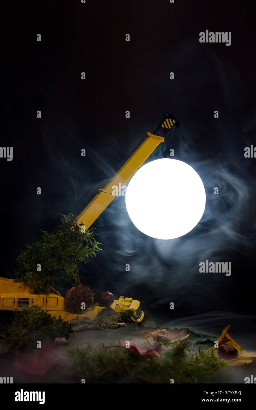 A crane in a mysterious landscape lifting up the moon Stock Photo - Alamy