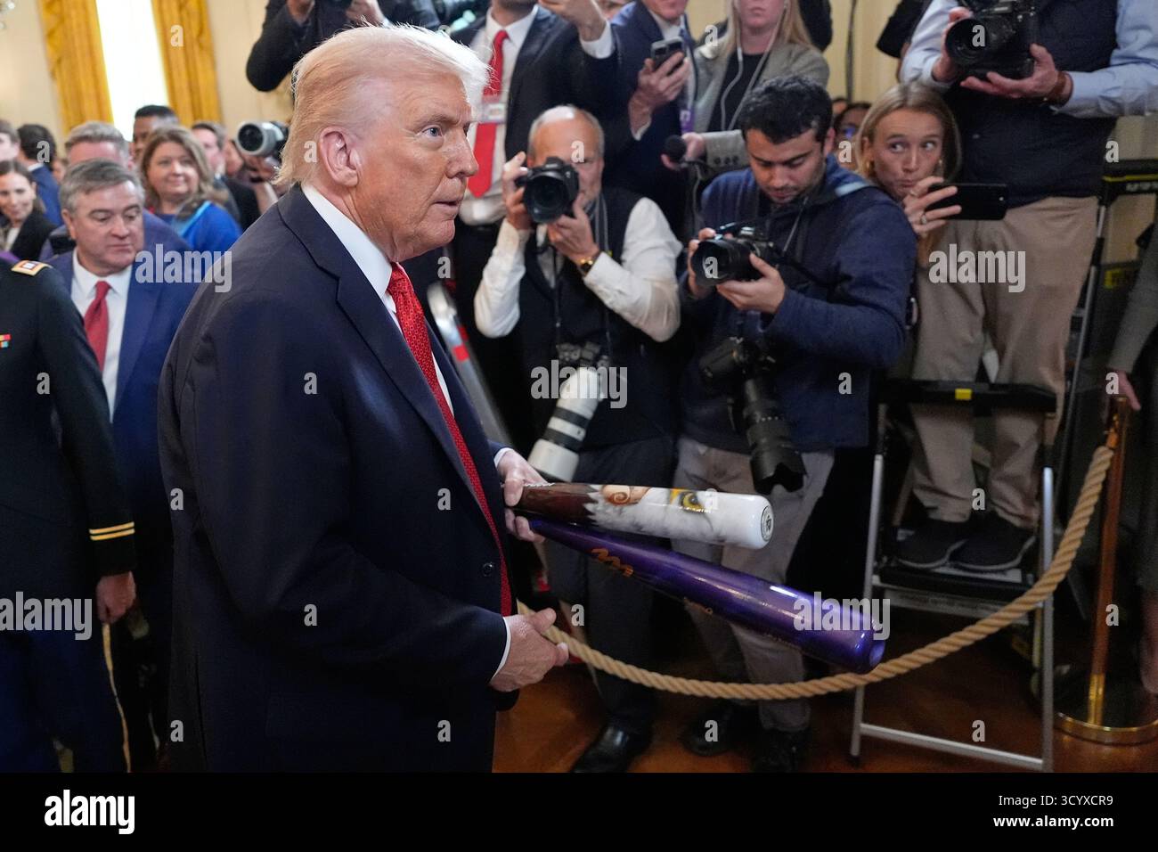 President Donald Trump departs holding bats after an event to welcome ...