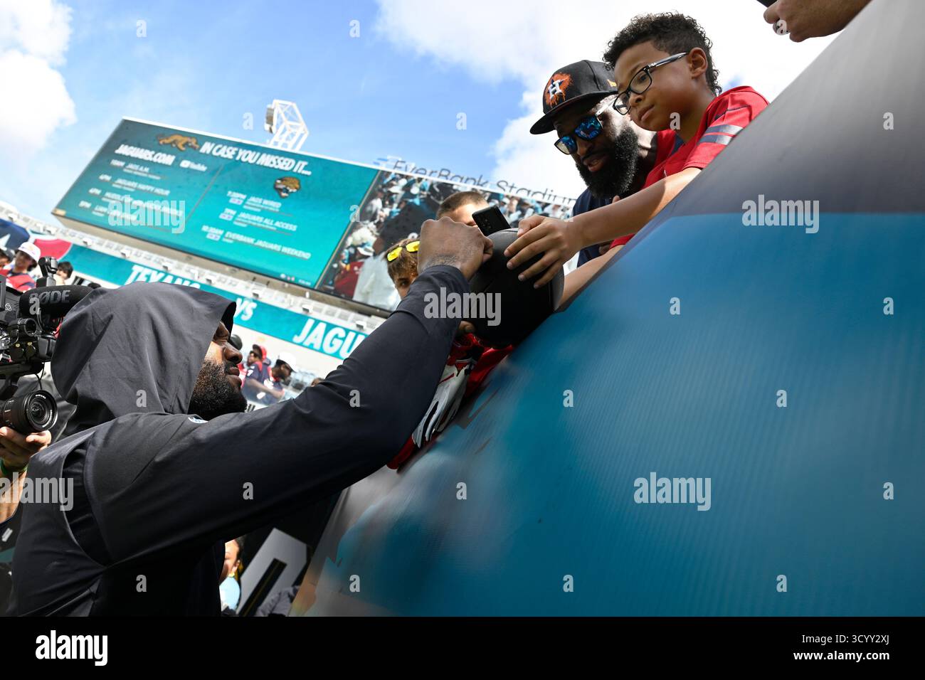 Houston Texans wide receiver Nico Collins, left, signs autographs for ...