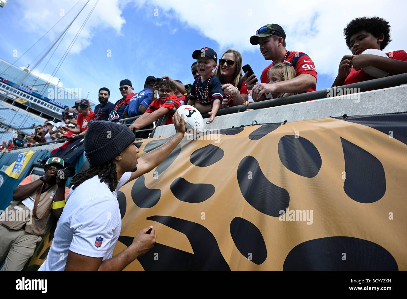 Houston Texans quarterback CJ. Stroud, left, signs autographs for fans ...