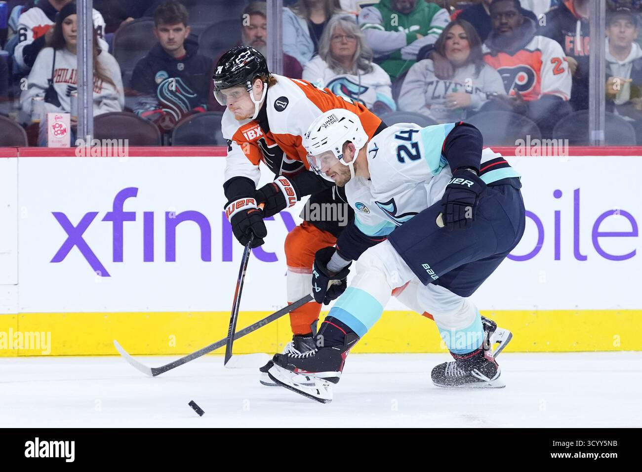 Philadelphia Flyers' Owen Tippett, left, passes the puck against ...