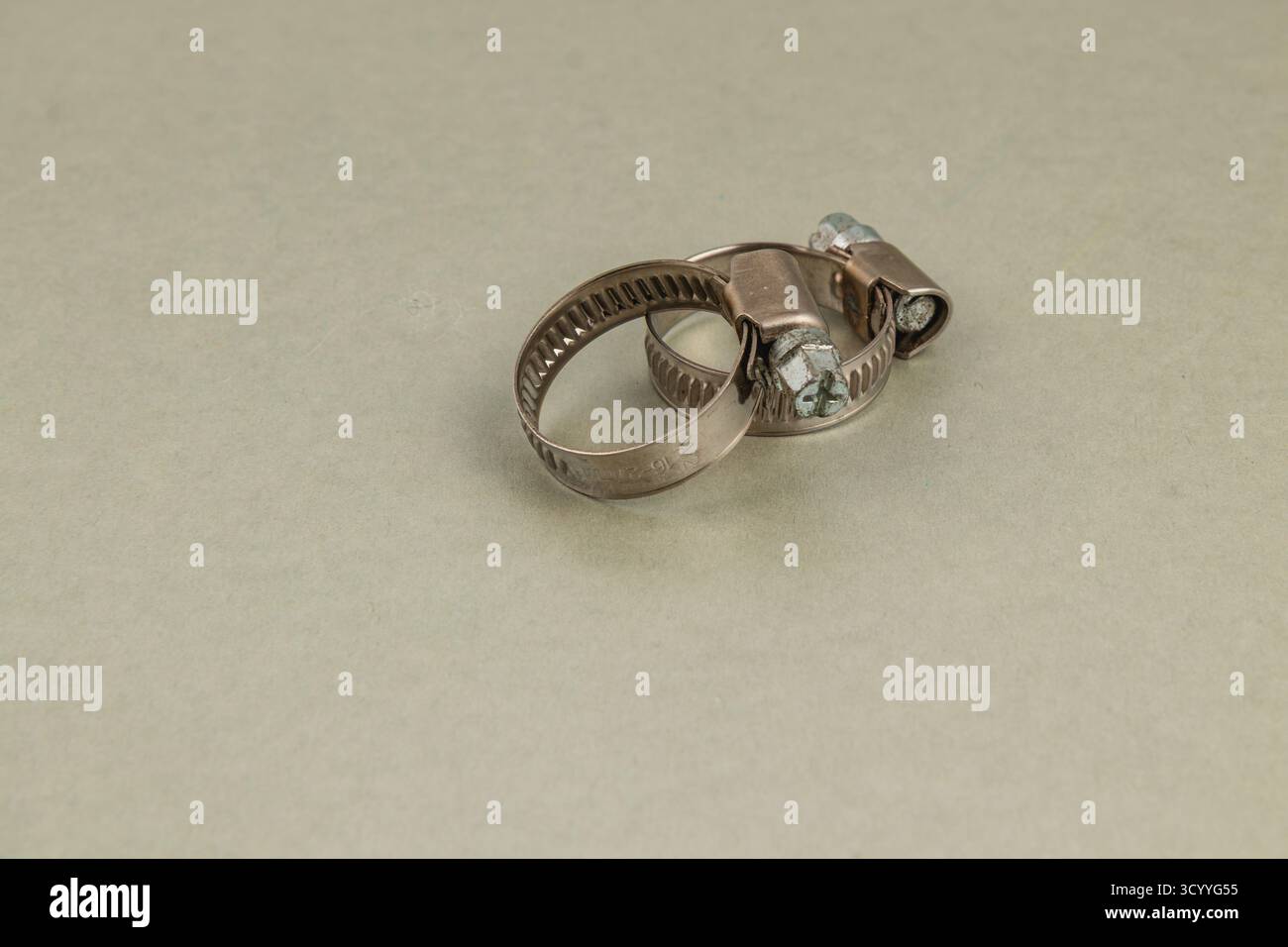 Metal clamps and rings rest on a simple surface, likely part of a ...