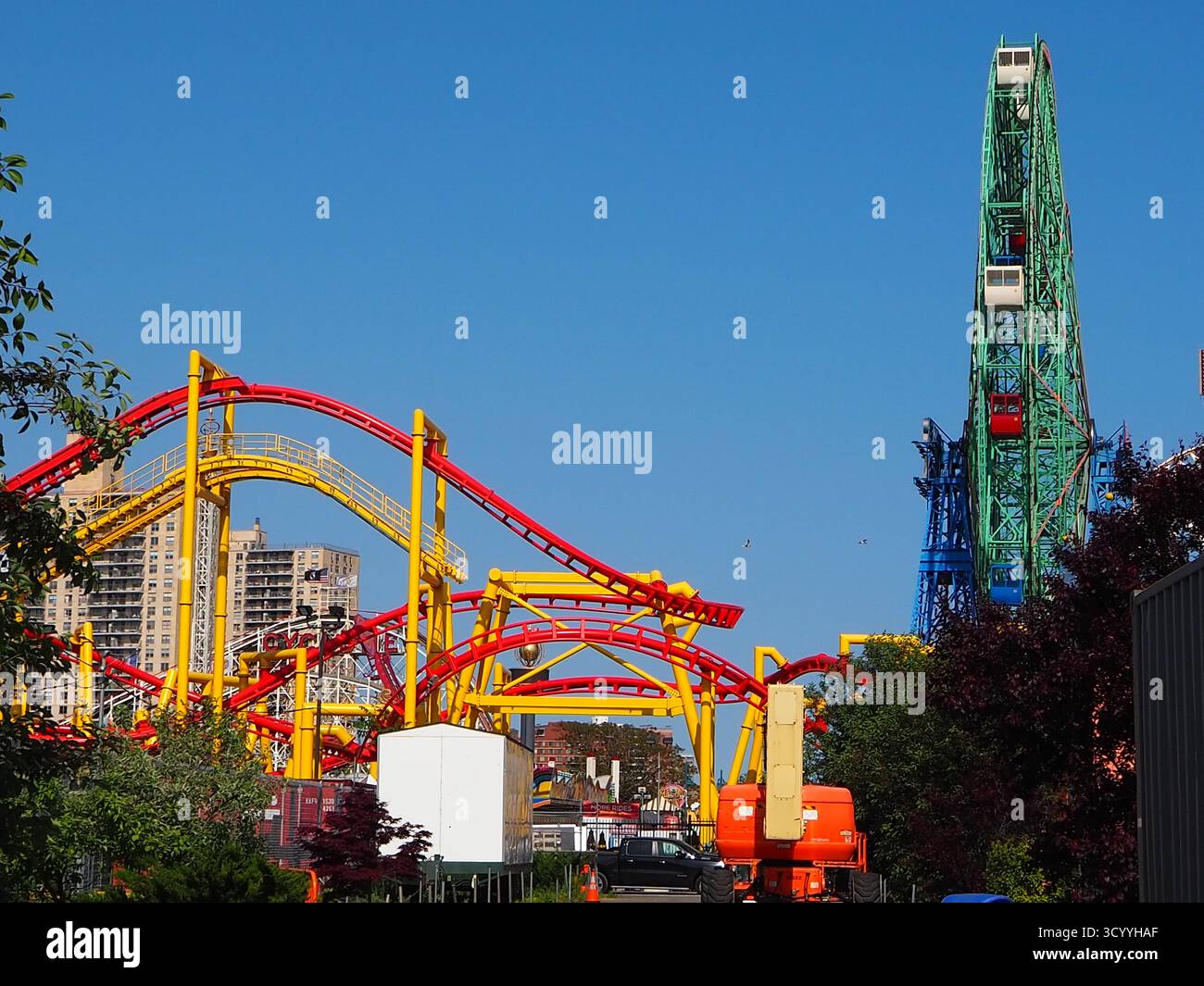 Colorful roller coaster and Wonder Wheel at Coney Island amusement park ...