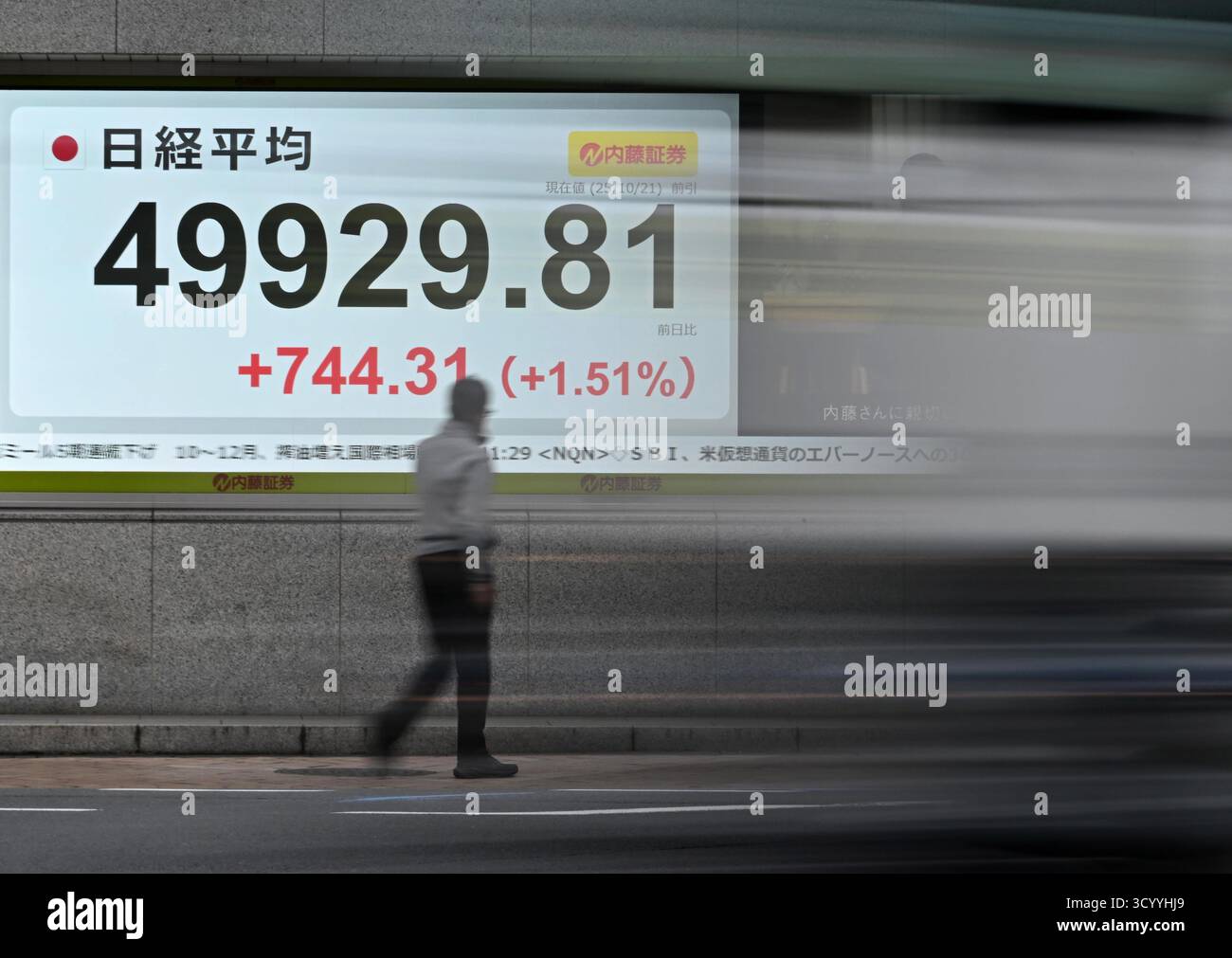 A monitor displays the Nikkei stock average, which briefly hit a record ...