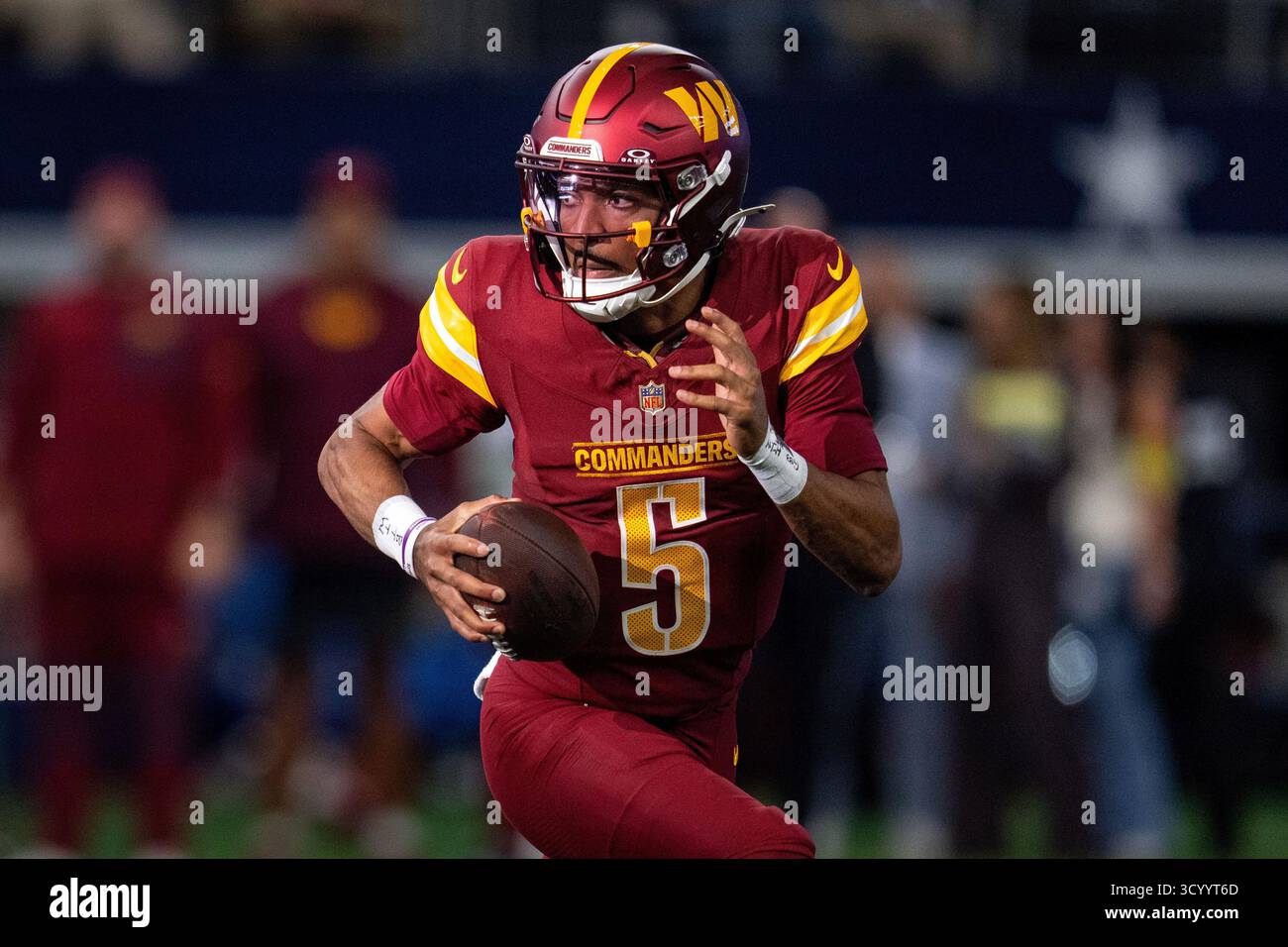 Washington Commanders quarterback Jayden Daniels rolls out to pass ...