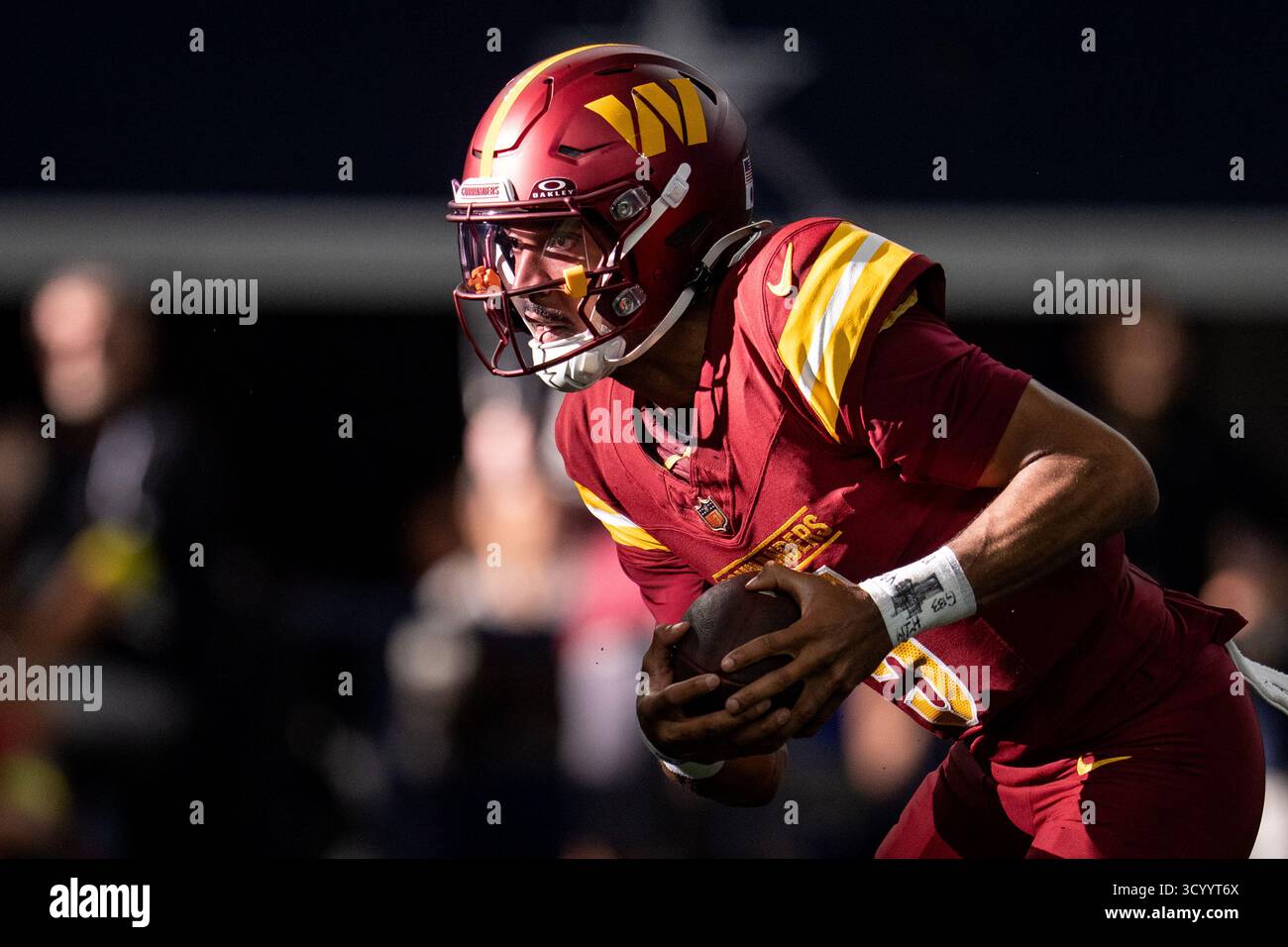 Washington Commanders quarterback Jayden Daniels carries the ball ...
