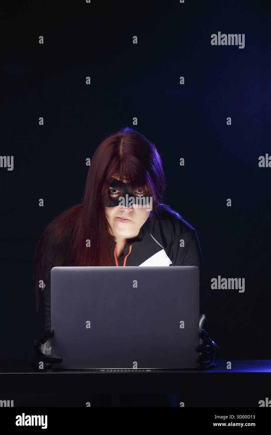 Portrait of burglar with computer at night Stock Photo - Alamy