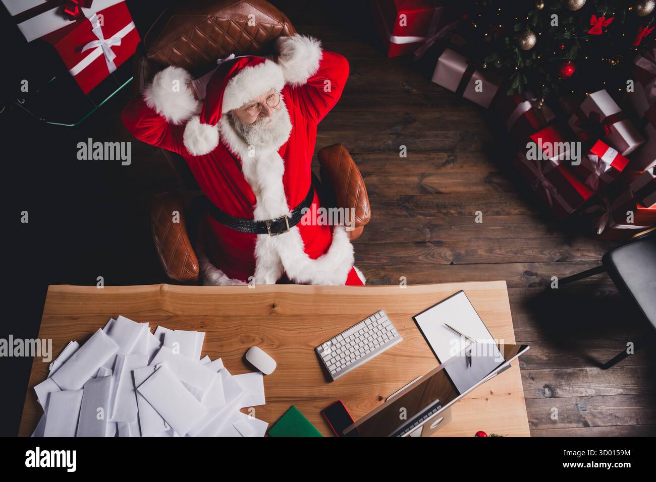 Santa at a cluttered desk full of papers and technology surrounded by ...