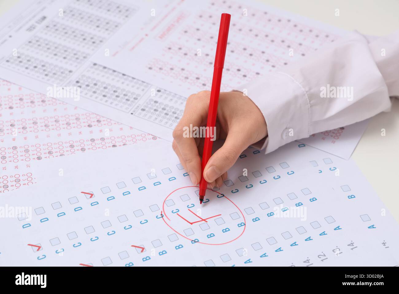 Female teacher writing results in answer sheets form of school test ...