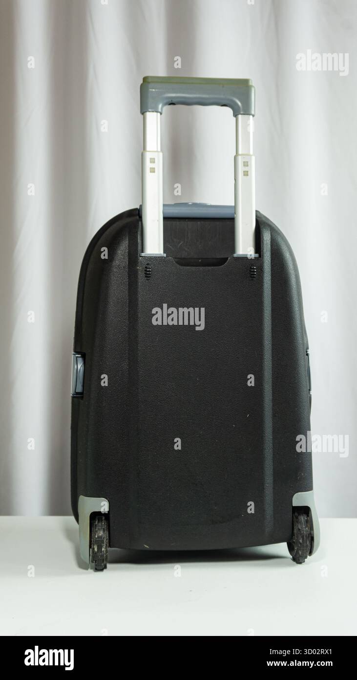 Portrait frame of upright suitcase viewed from the back, white fabric ...