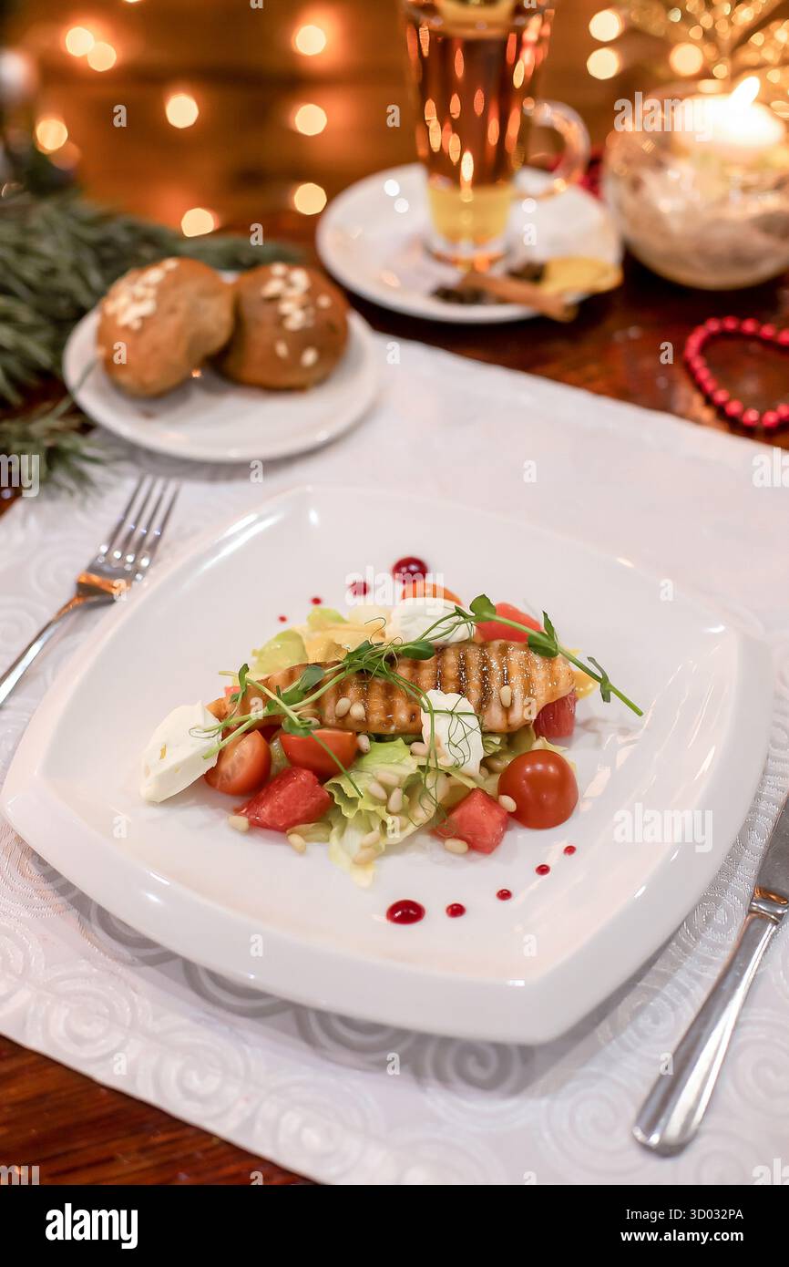 Grilled fish salad with mozzarella, cherry tomatoes, and pine nuts on ...