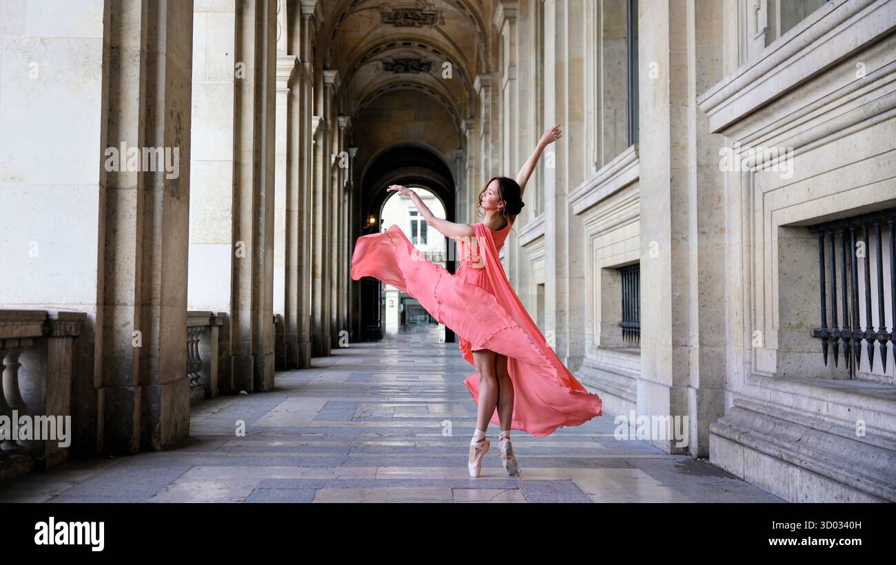 Ballet dancer in red dress flying under historic stone arch in Paris ...