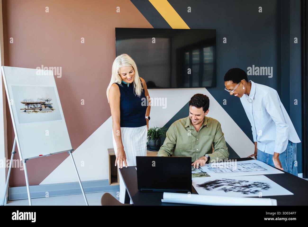 Three professionals review architectural hi-res stock photography and ...