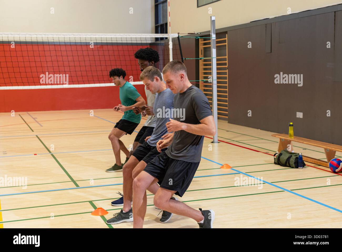 Diverse male athletes practicing footwork drills at gym using orange ...