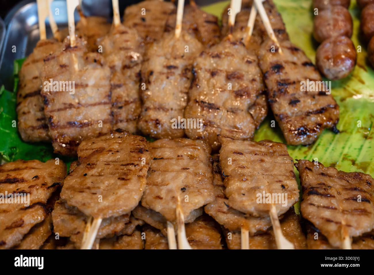 Traditional meat on a stick, grilled pork satay or moo ping in Thailand ...