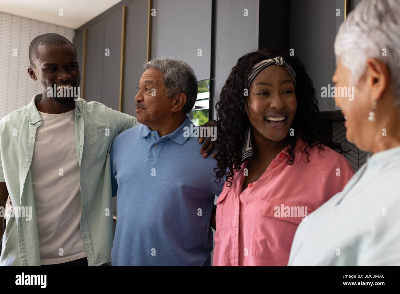 Three generations of family smiling and talking together in modern ...