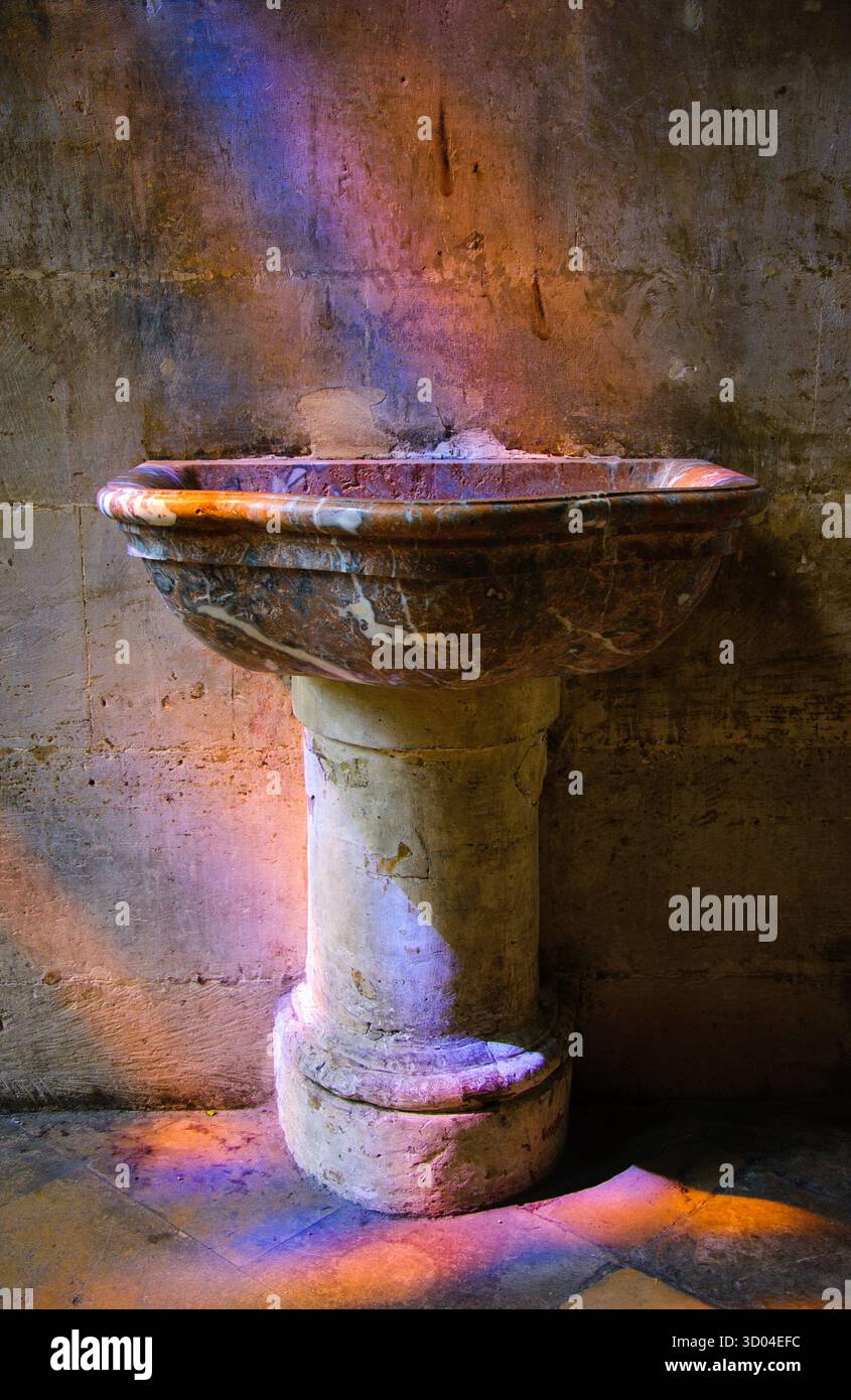 Colorful light spots on the holy water stoup, the tiled floor and the ...