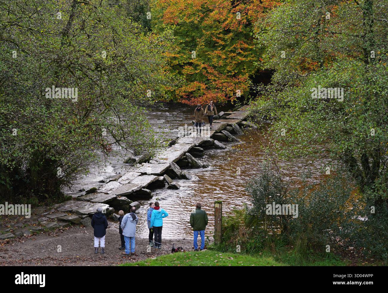 People walking on the Tarr Steps - an ancient clapper bridge dating ...