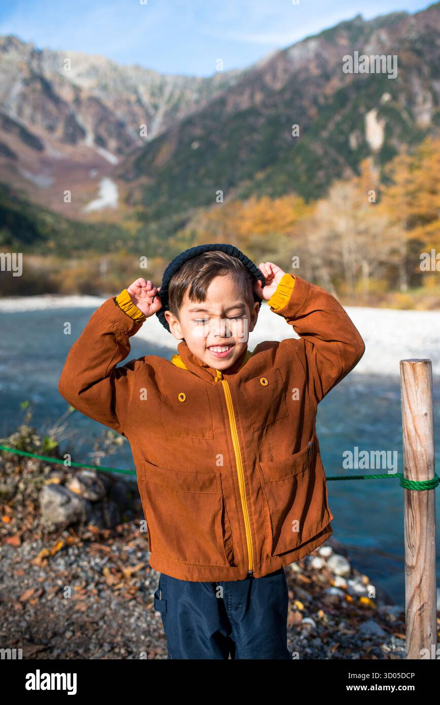 a smilling boy adjusting a winter hat, during a trail in the national ...
