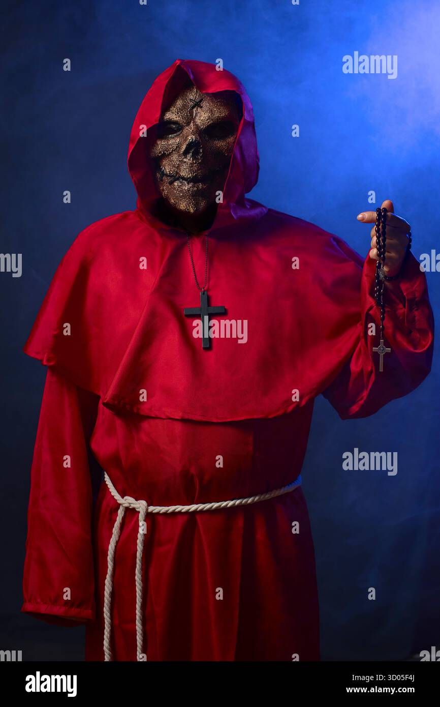 Monk with a red robe, a scary mask, a cross in his chest and a prayer ...