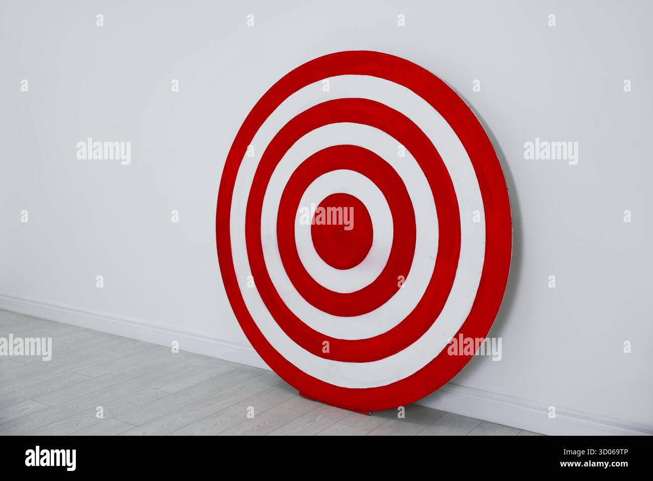 Round shooting target on floor near white wall Stock Photo - Alamy
