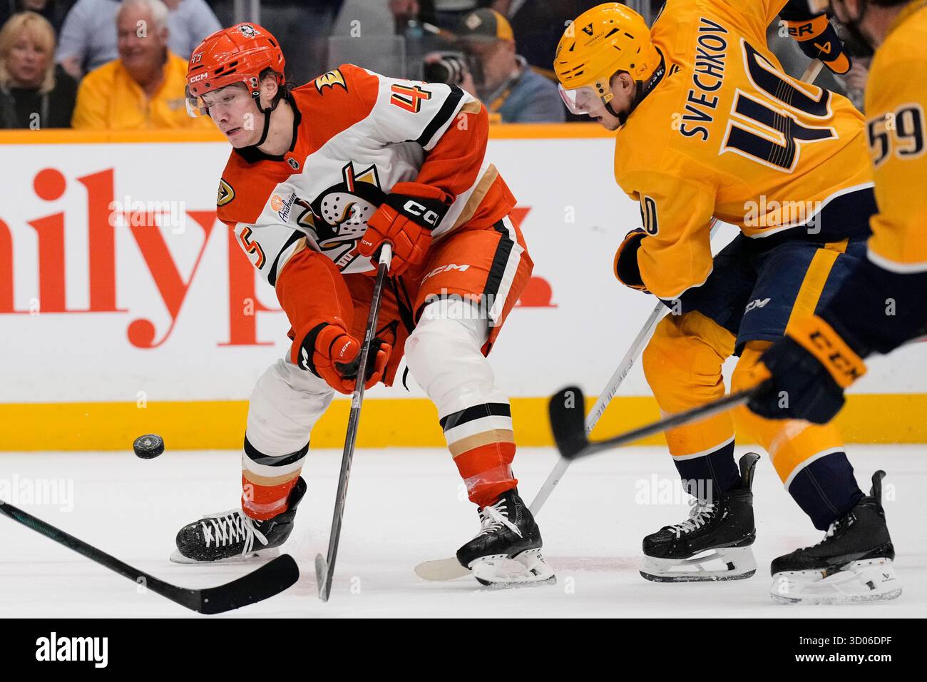 Anaheim Ducks right wing Beckett Sennecke, left, passes the puck away ...