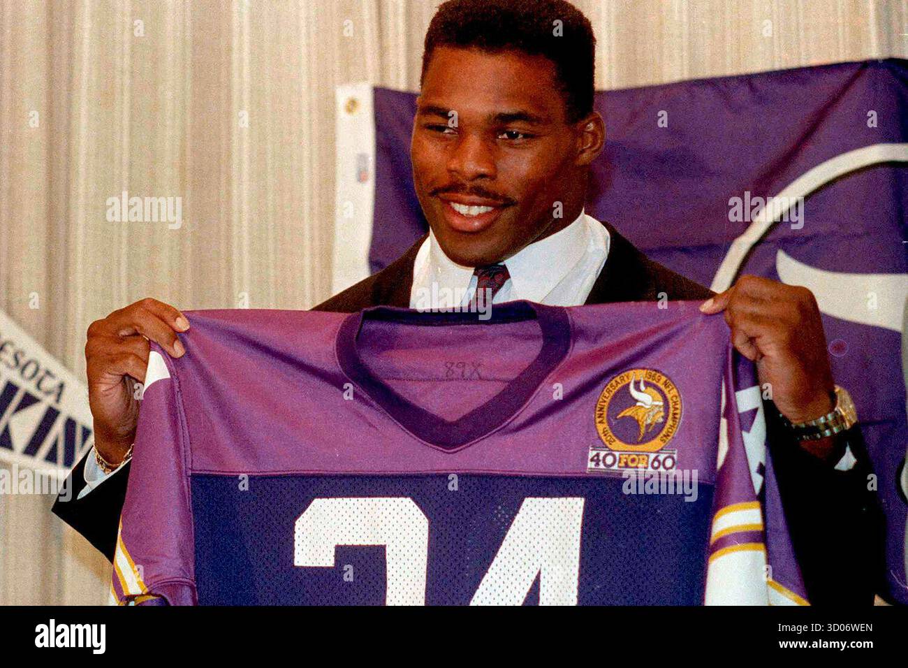 FILE - Former Dallas Cowboys running back Herschel Walker holds up ...