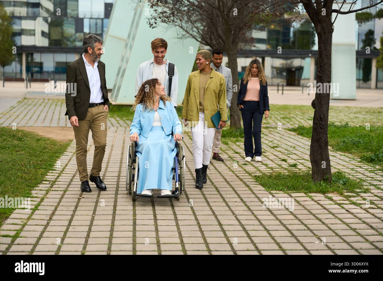 Diverse business team assisting woman in wheelchair Stock Photo - Alamy