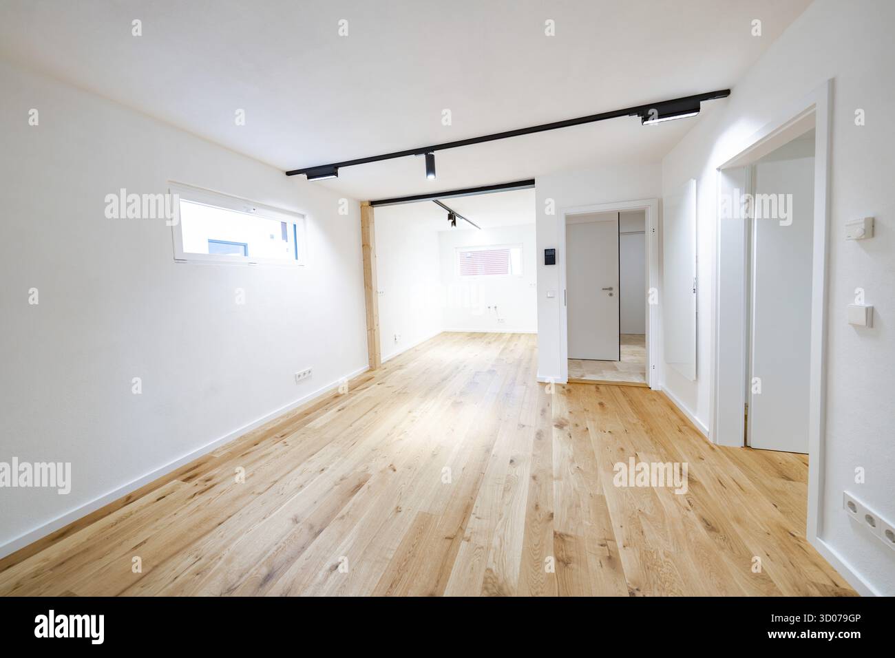 Bright living room with oak flooring and black track lights in a modern ...