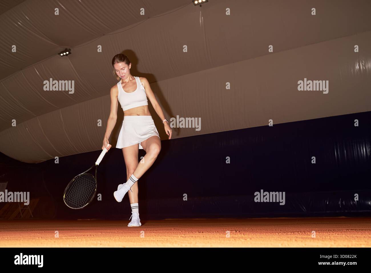 Young adult Caucasian woman playing tennis indoors, balancing tennis ...